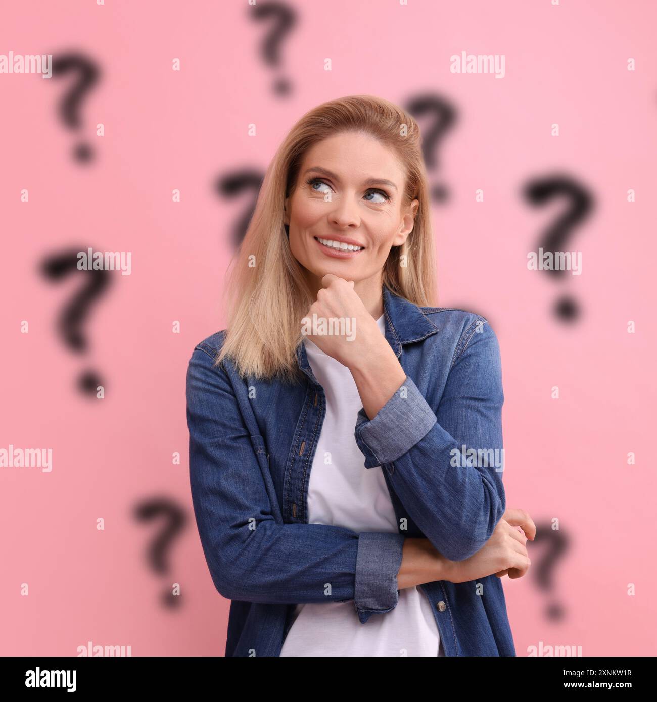 Smiling woman thinking about something on pink background. Question ...