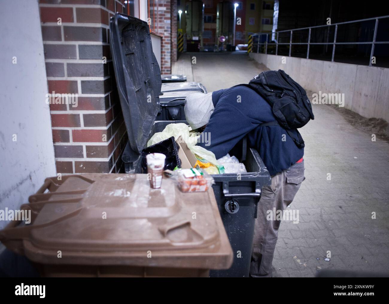Student searching for edible food in supermarket dumpsters at night in ...