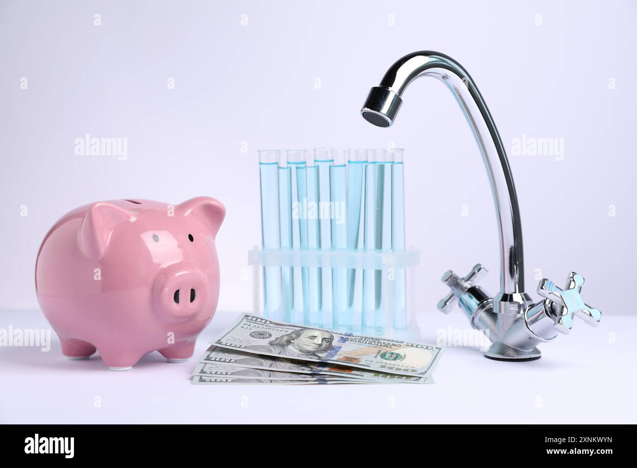 Water saving concept. Piggy bank, tap, test tubes with liquid and ...