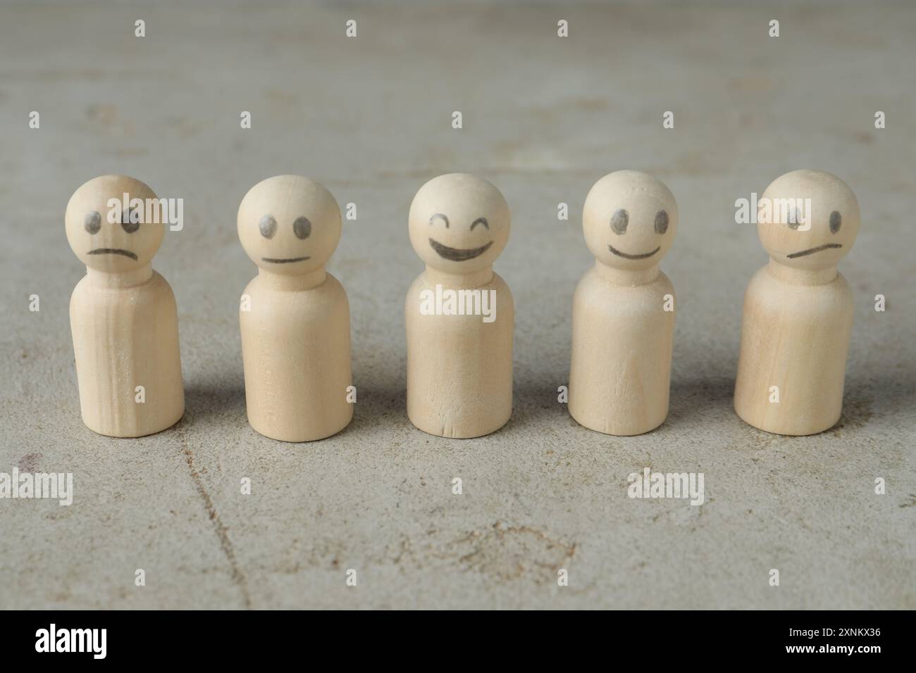Wooden figures showing different emotions on grey table Stock Photo - Alamy