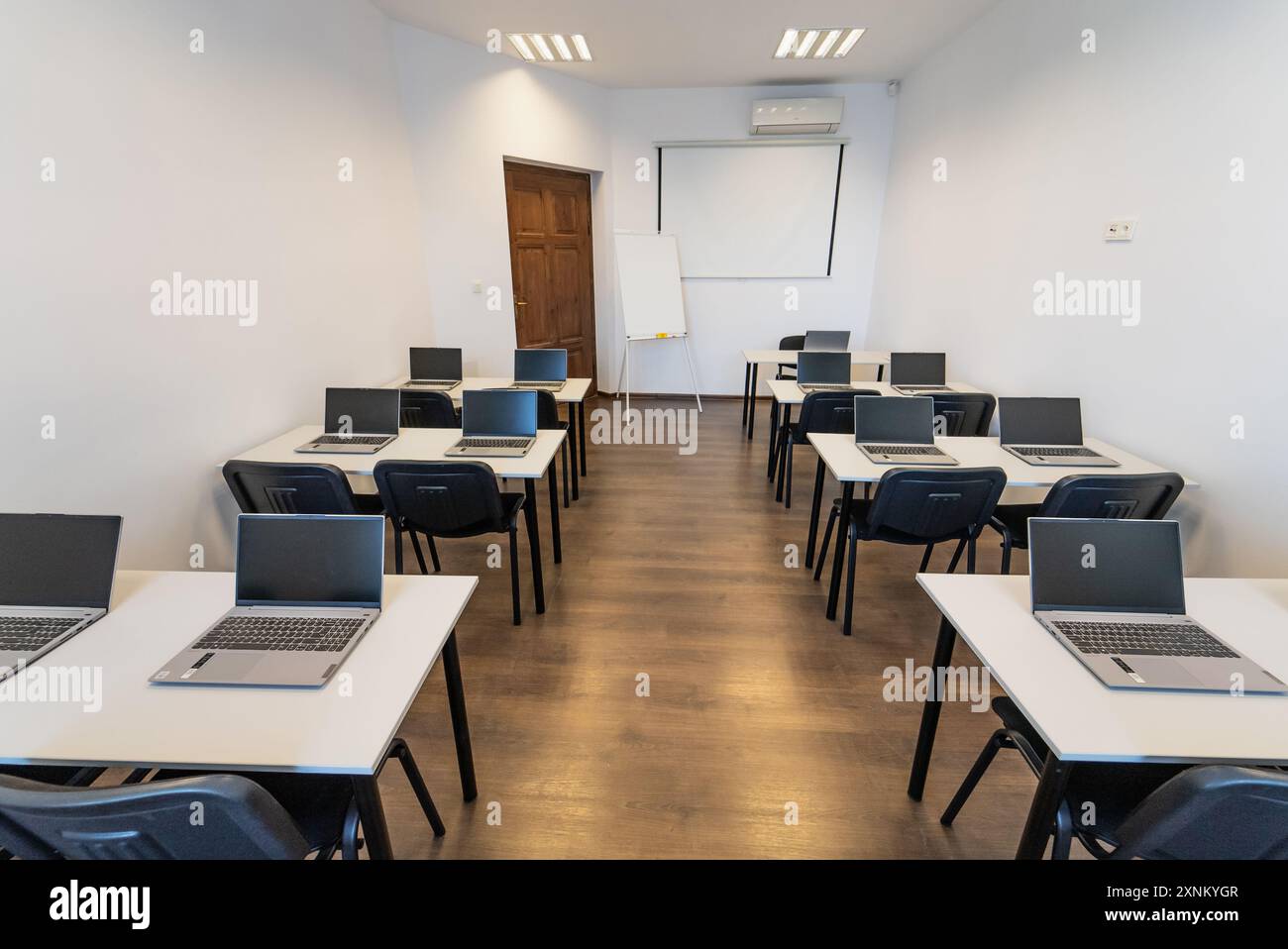 Interior of a modern classroom with desks, chairs and laptops. Empty ...