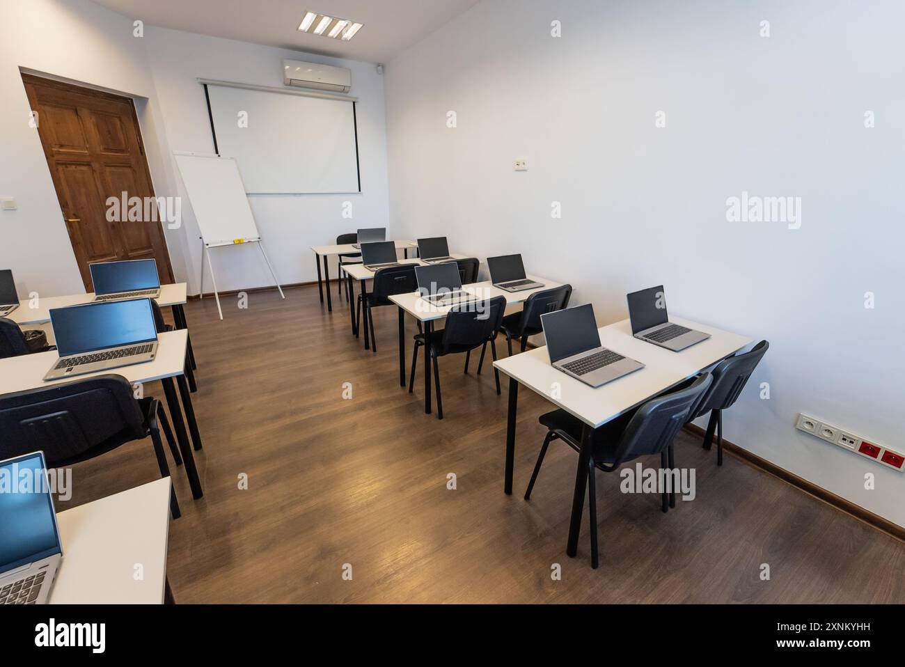 Interior of a modern classroom with desks, chairs and laptops. Empty ...