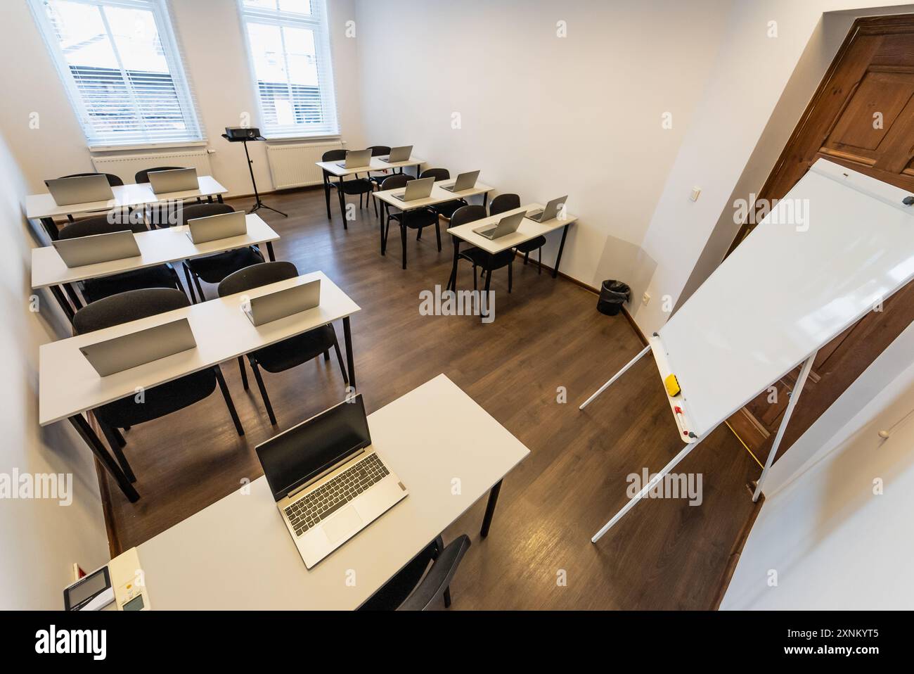 Interior of a modern classroom with desks, chairs and laptops. Empty ...