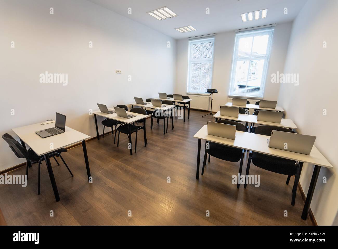 Interior of a modern classroom with desks, chairs and laptops. Empty ...