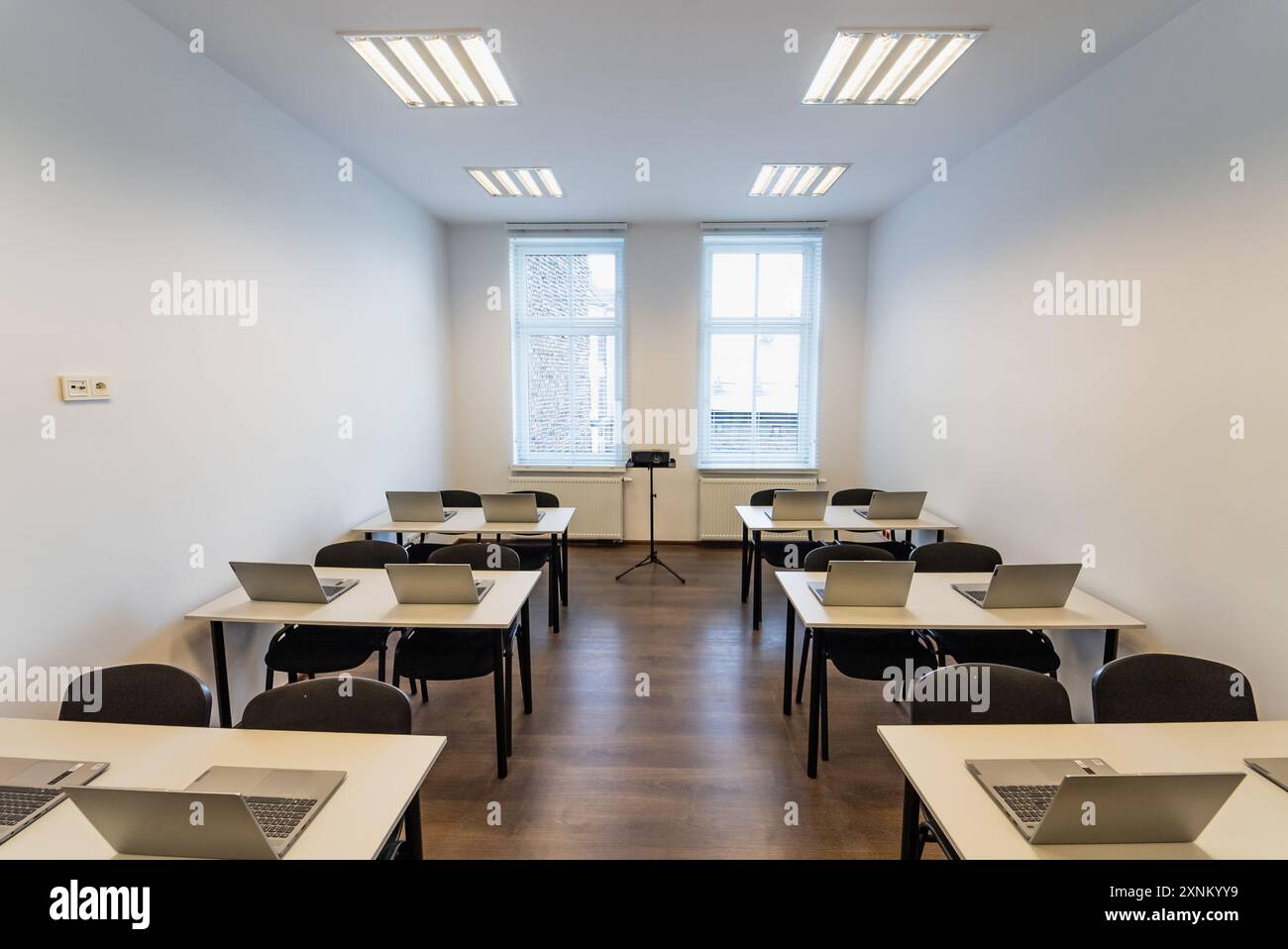 Interior of a modern classroom with desks, chairs and laptops. Empty ...