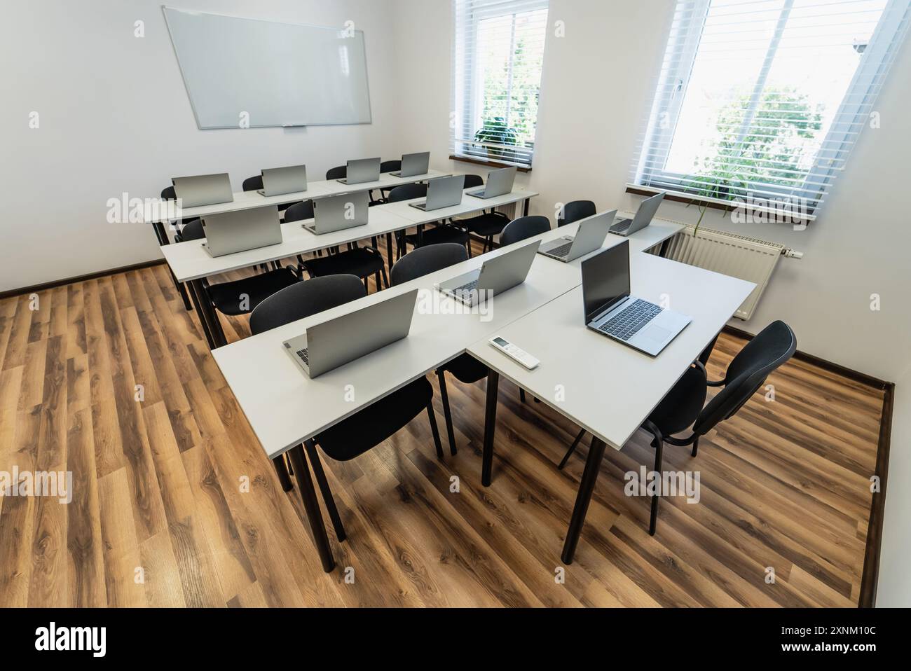 Interior of a modern classroom with desks, chairs and laptops. Empty ...