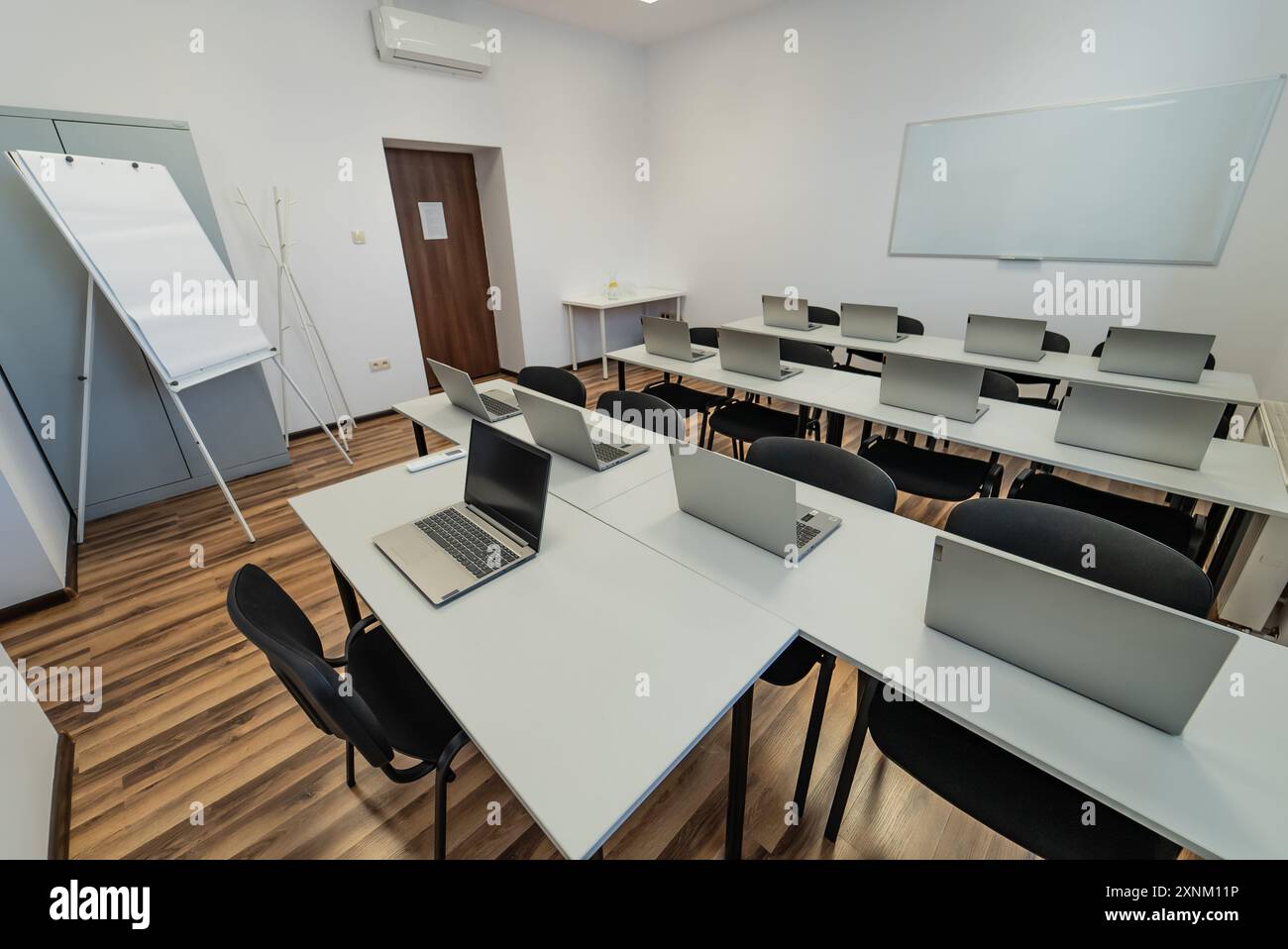 Interior of a modern classroom with desks, chairs and laptops. Empty ...