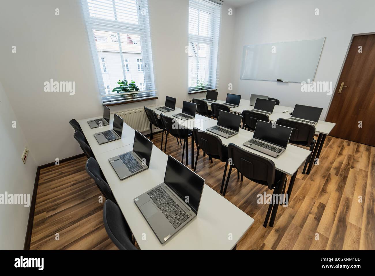 Interior of a modern classroom with desks, chairs and laptops. Empty ...
