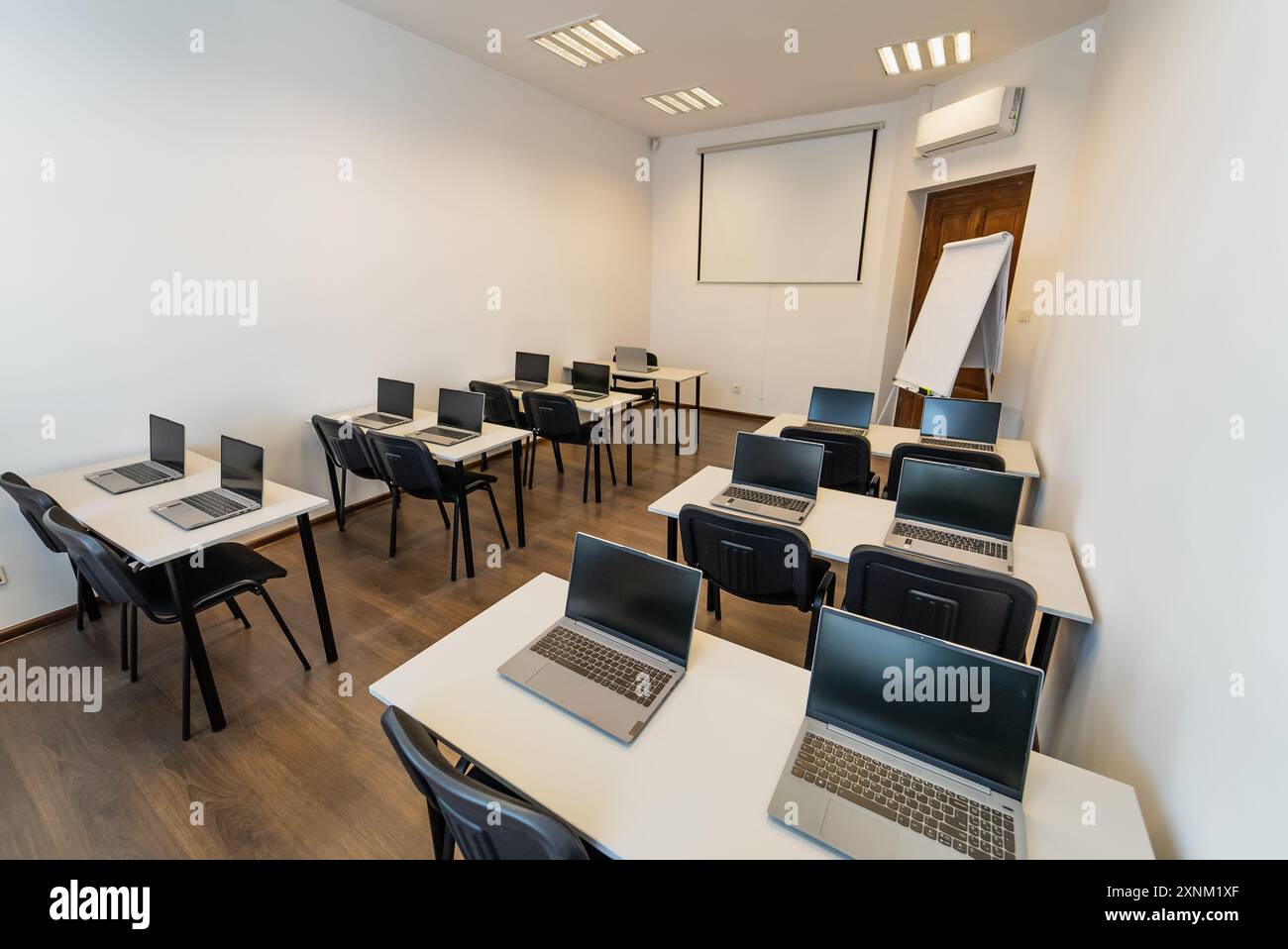Interior of a modern classroom with desks, chairs and laptops. Empty ...
