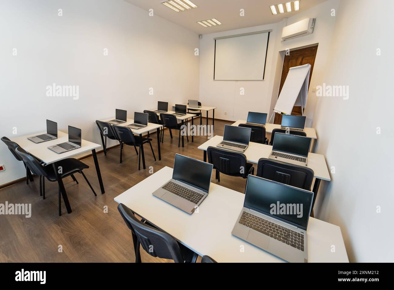 Interior of a modern classroom with desks, chairs and laptops. Empty ...