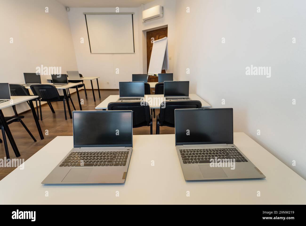 Interior of a modern classroom with desks, chairs and laptops. Empty ...