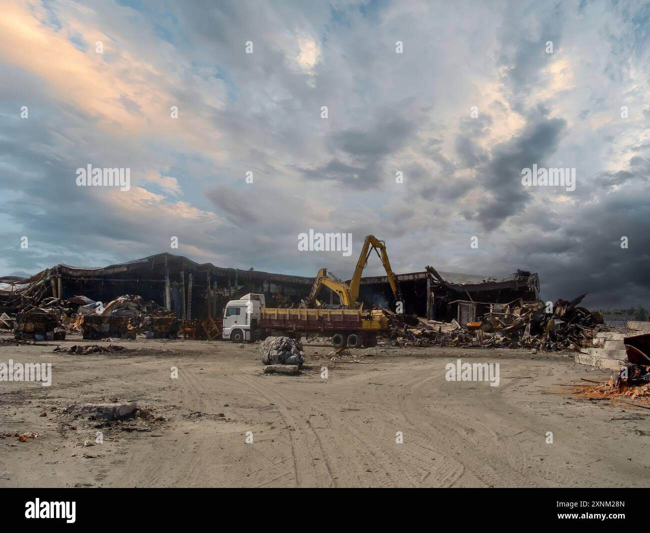 Post-fire cleanup of a destroyed warehouse, featuring a truck and ...