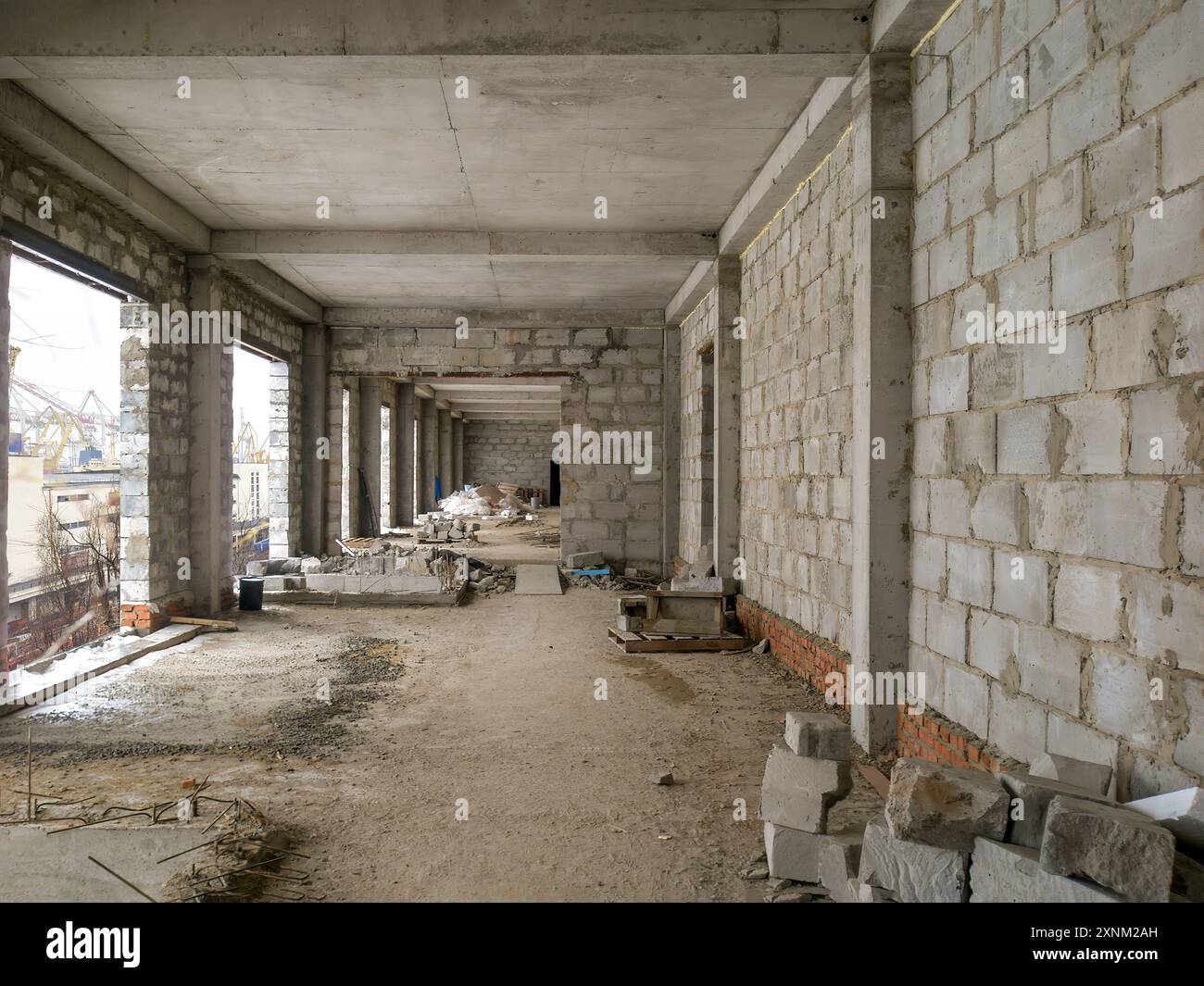 Unfinished construction site showing raw concrete walls and scattered ...