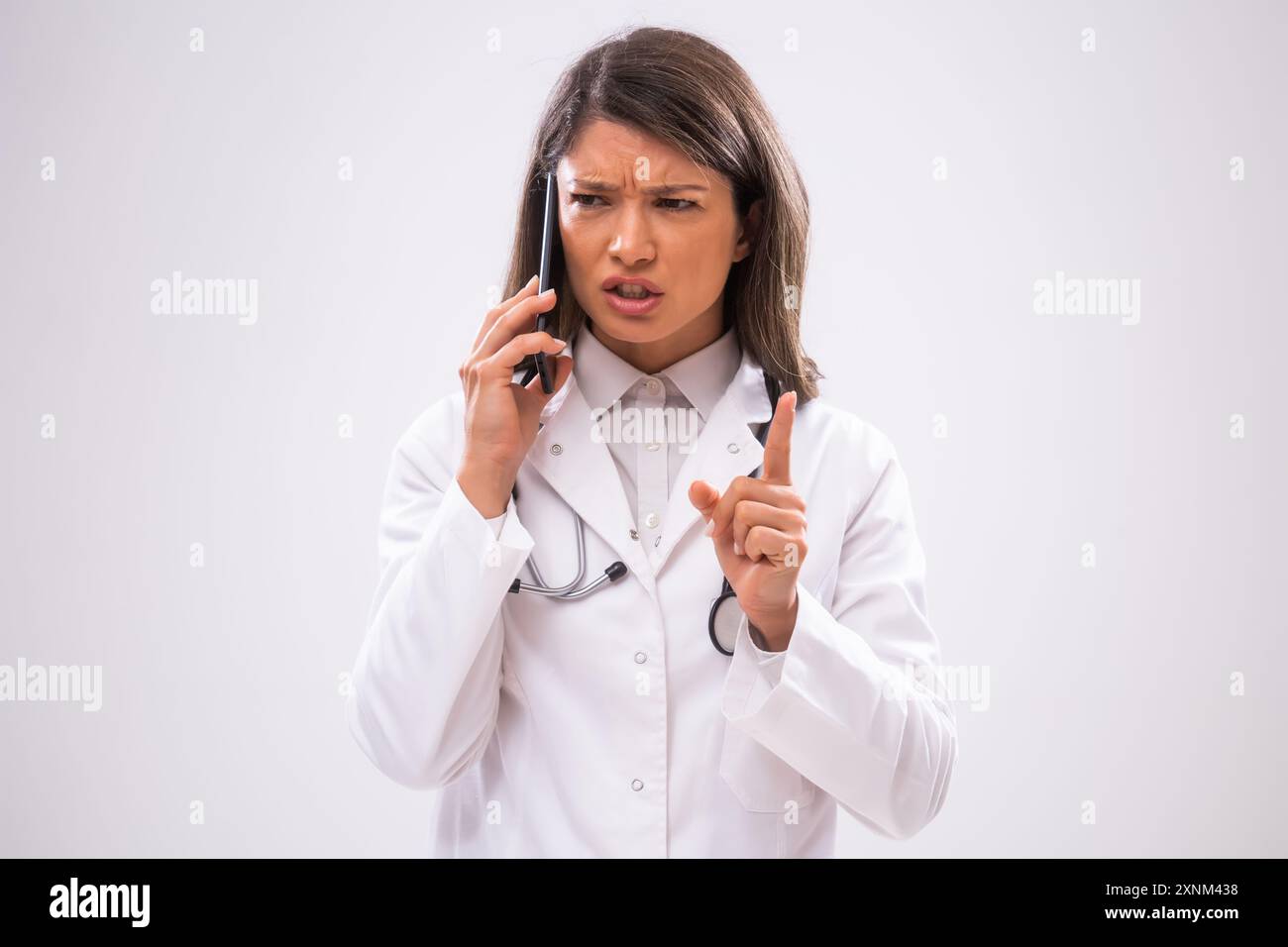 Portrait of angry doctor who is talking on phone with patient Stock ...