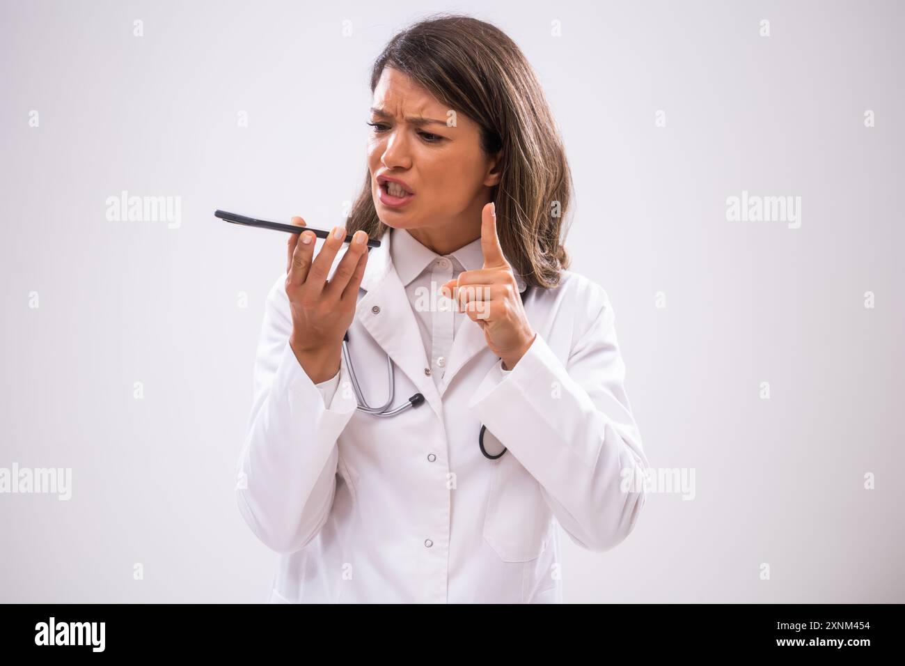 Portrait of angry doctor who is talking on phone with patient Stock ...
