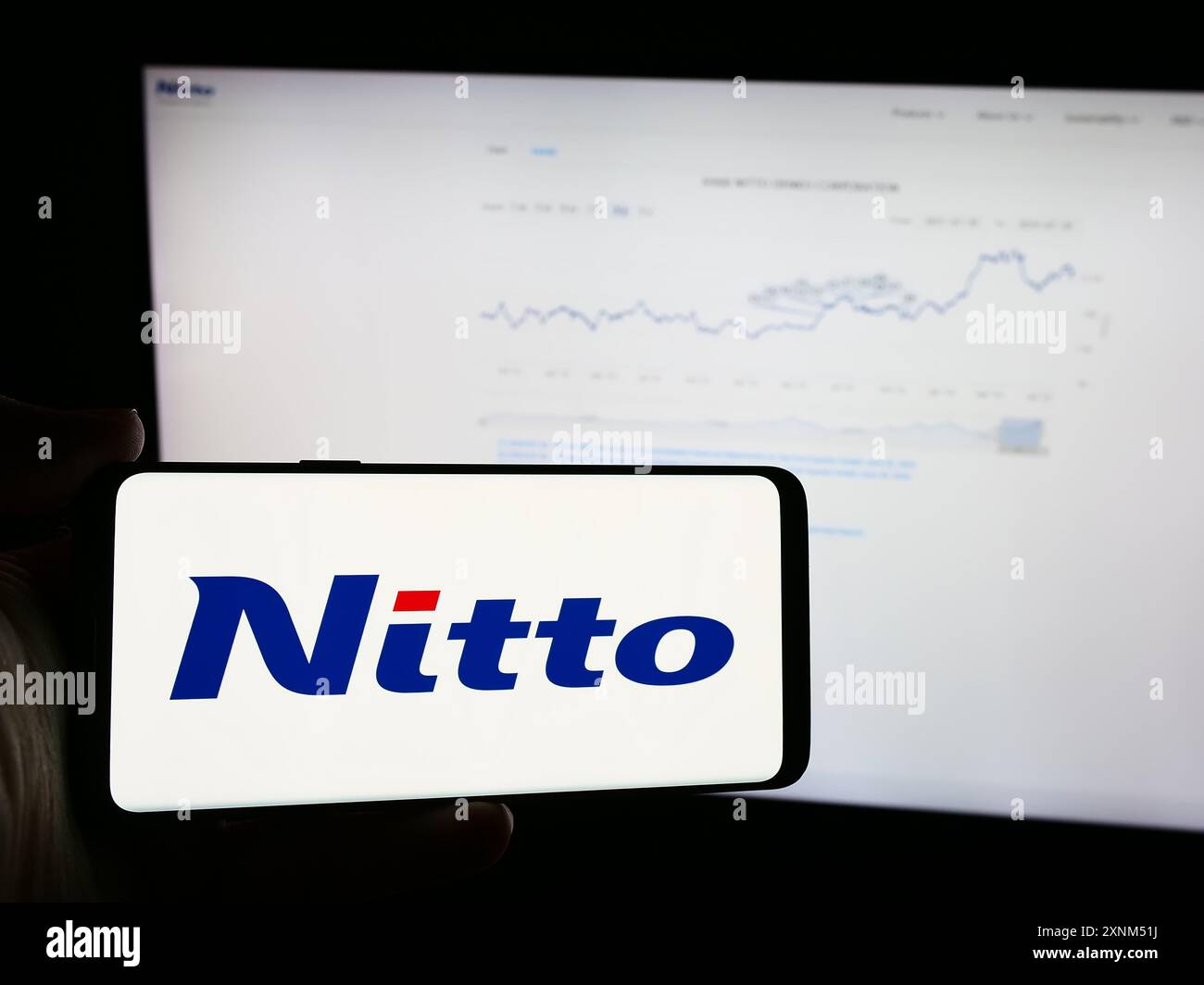 Person holding mobile phone with logo of Japanese chemical company ...