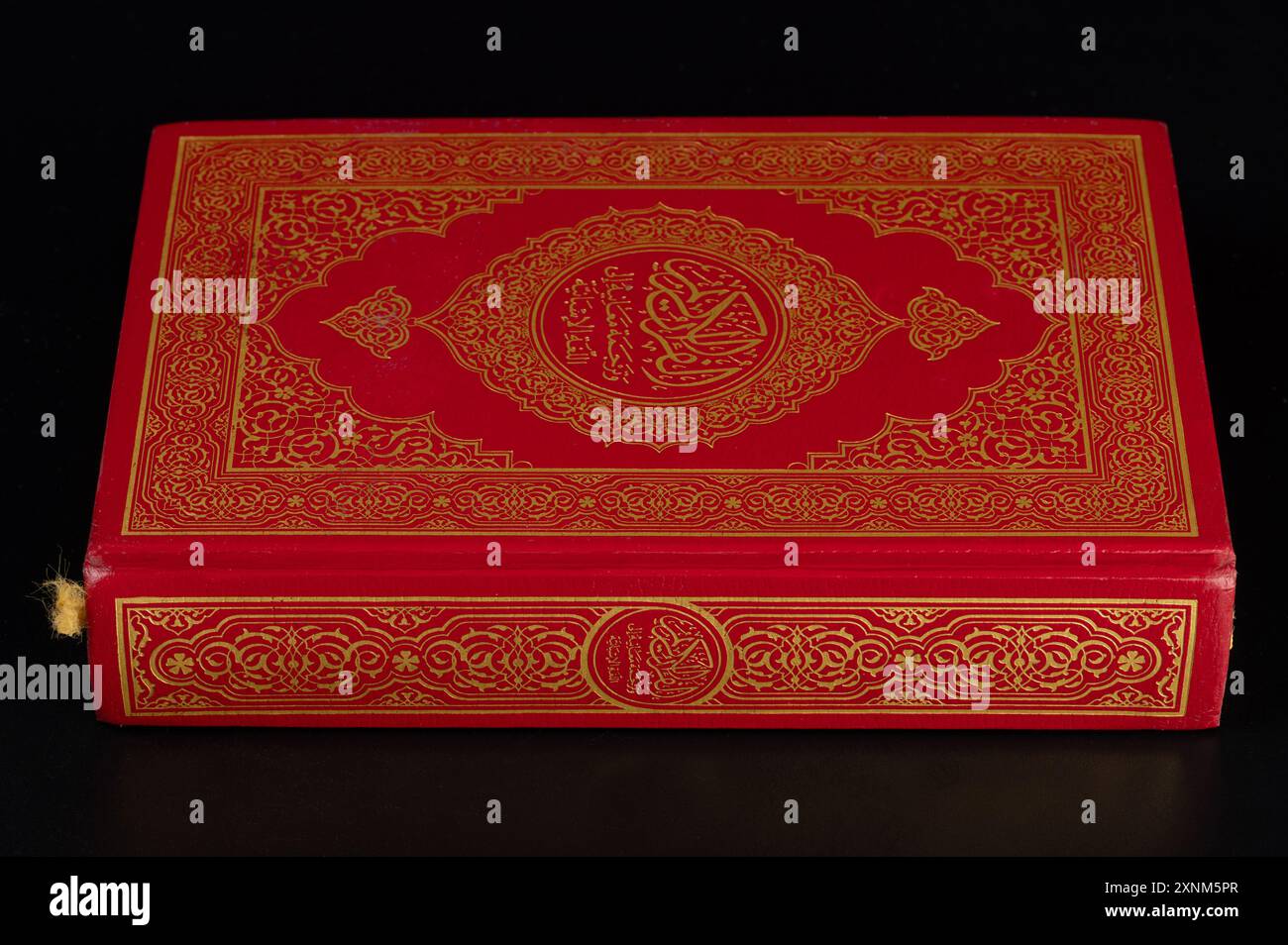 Closed red koran book side view isolated on black studio background Stock Photo - Alamy