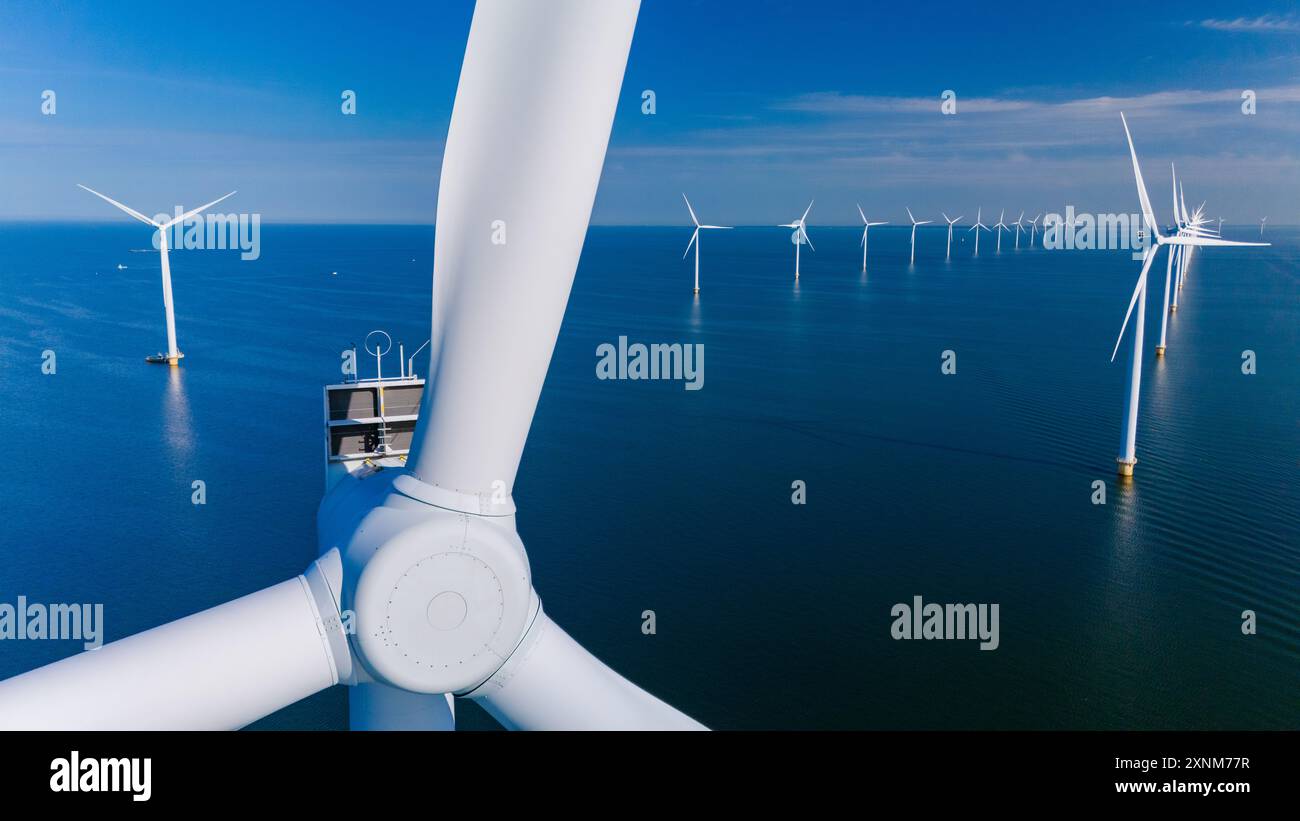 Offshore wind turbines spin gracefully above tranquil waters ...