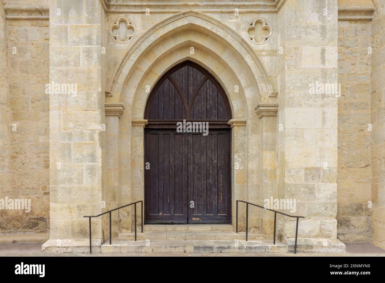 Exterior to an old christian church with wooden doors and stone brick ...