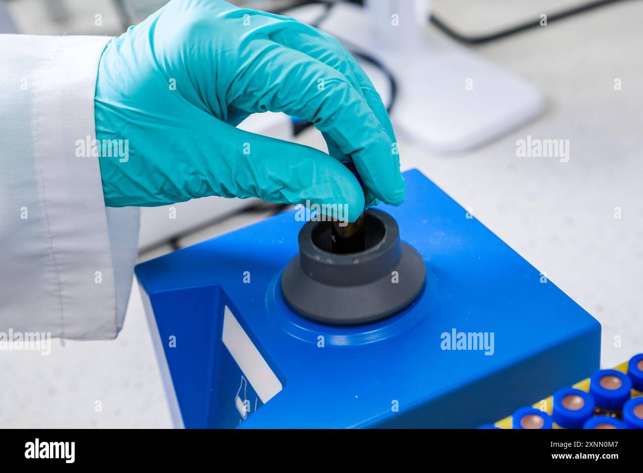 Prior to HPLC analysis, a chemist shakes samples using a vortex mixer ...