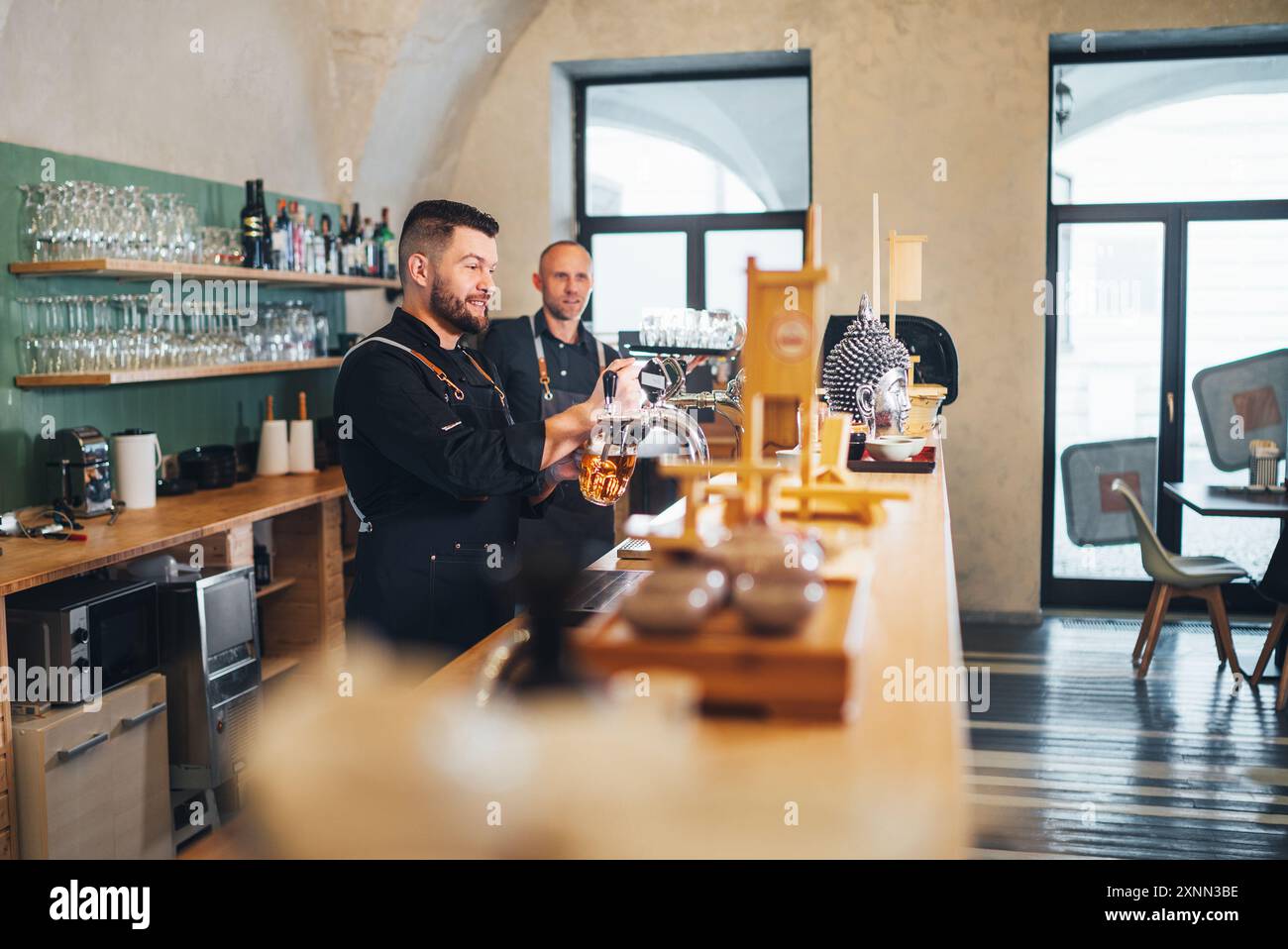 Two smiling caucasian men friends barman lager beer tapping and waiter ...