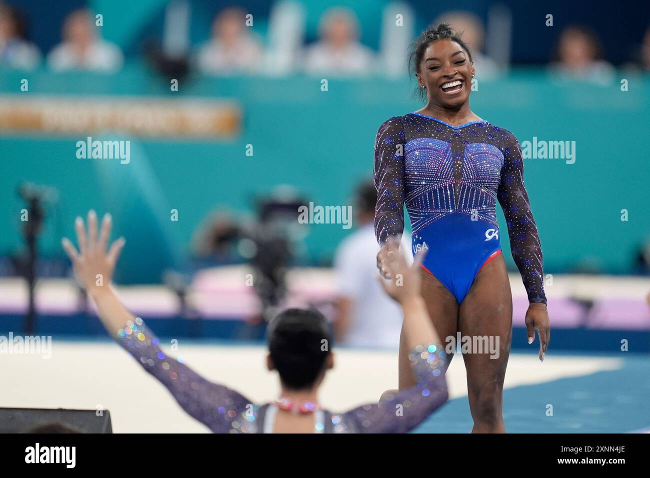 Simone Biles, top, celebrates with teammate Suni Lee, of the United ...