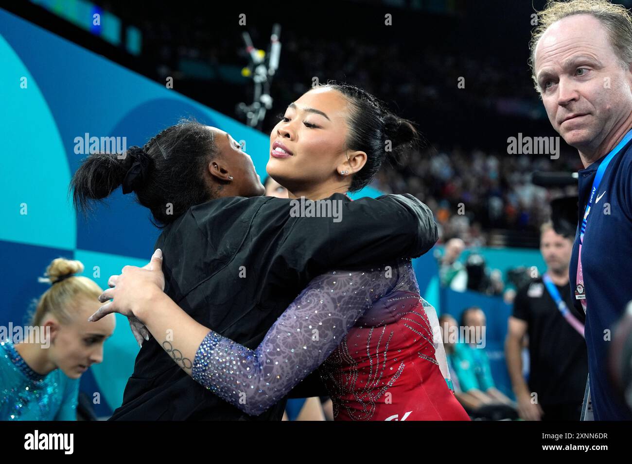 Simone Biles, left, hugs teammate Suni Lee, of the United States ...