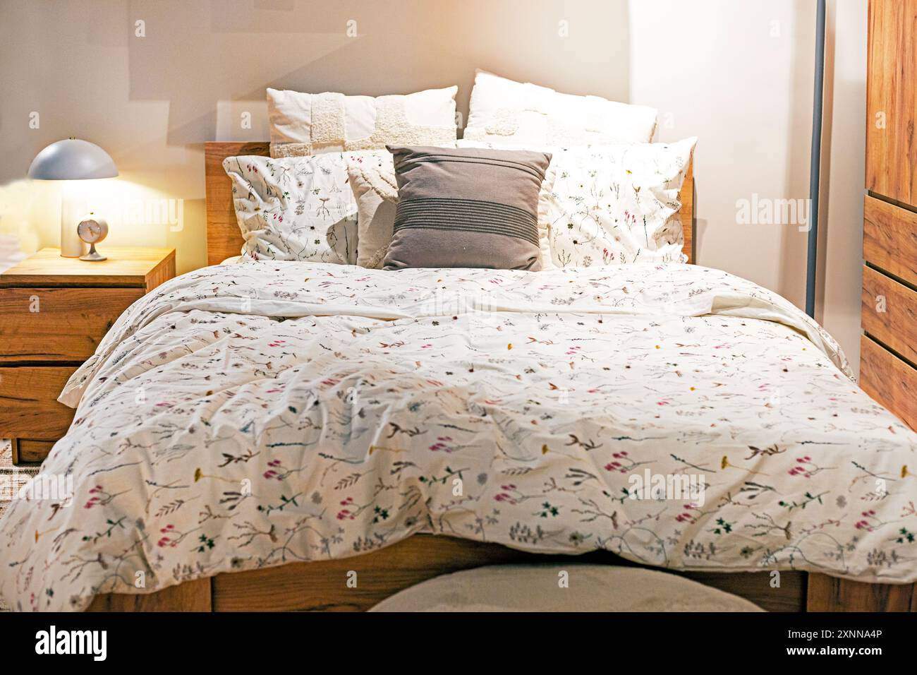 alarm clock is on the bedside table next to the bed. good morning, mode ...