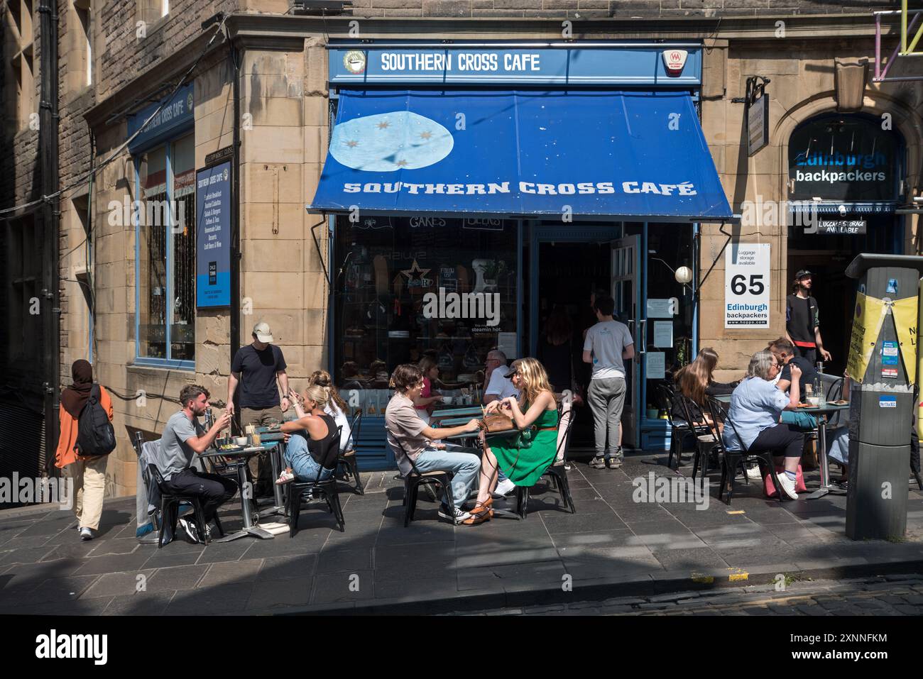Tourist sitting in the sunshine outisde the Southern Cross Cafe on ...
