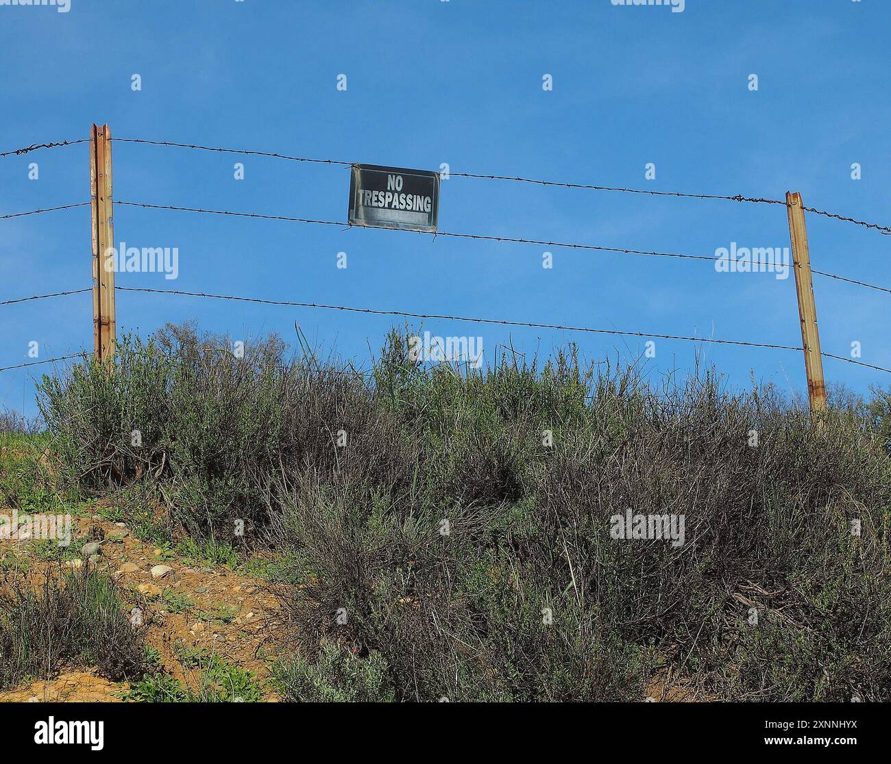 no trespassing sign on barbed wire fence in Southern California Stock ...