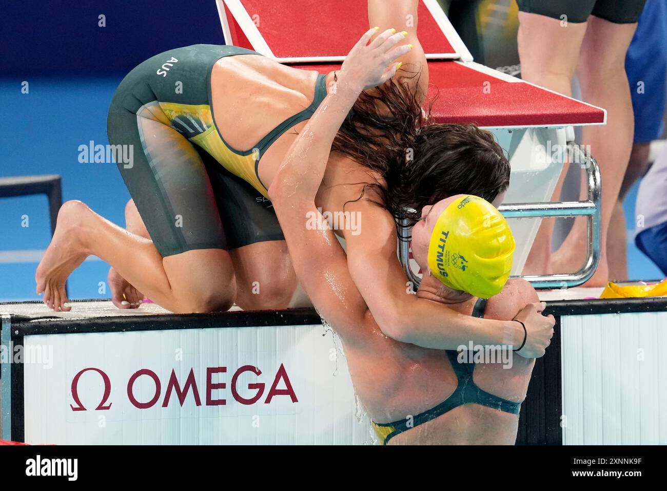 Australia's Ariarne Titmus gets a hug from a teammate after anchoring their team to victory in ...