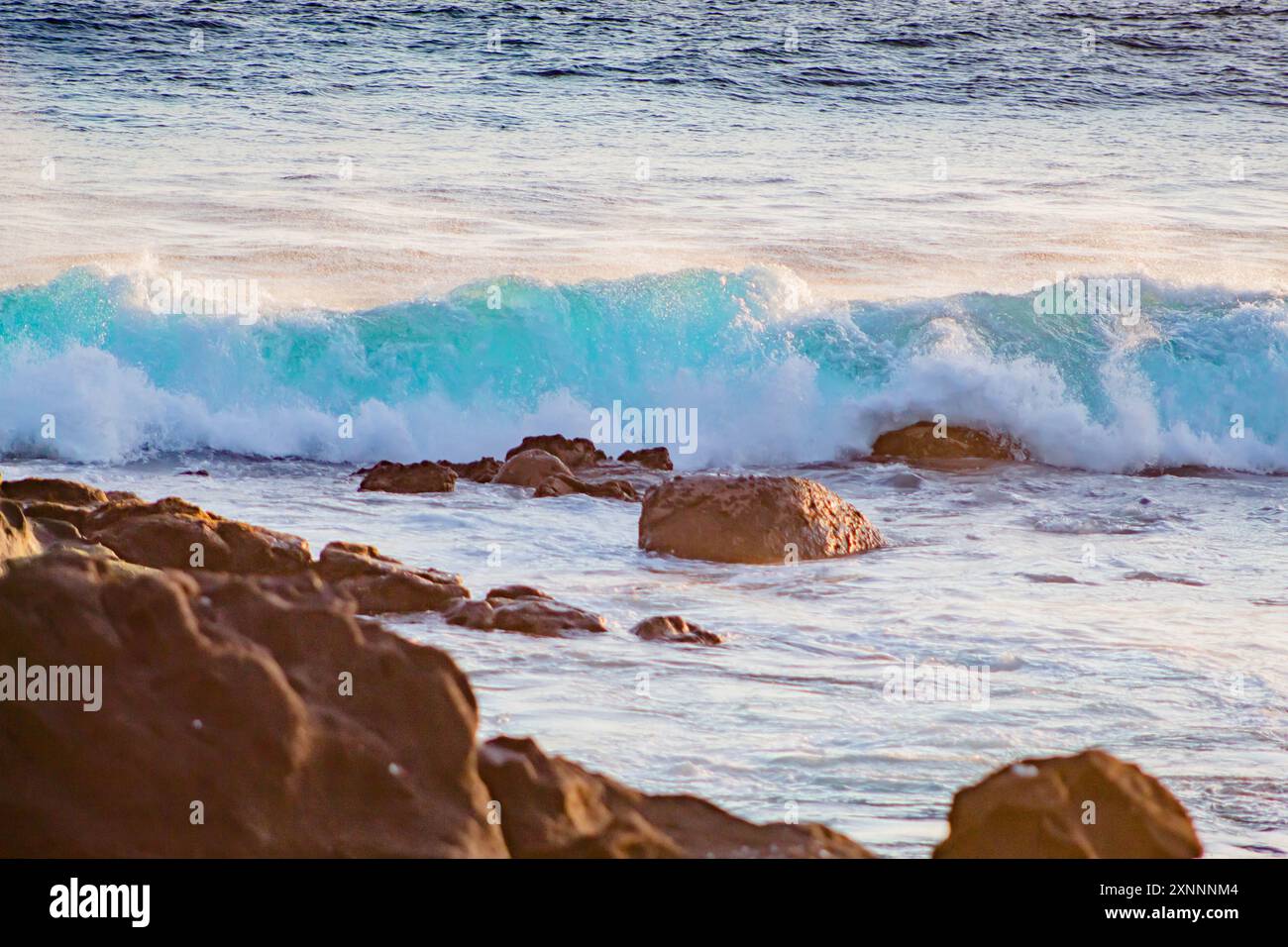 Reunionese wave dying on rocks Stock Photo - Alamy