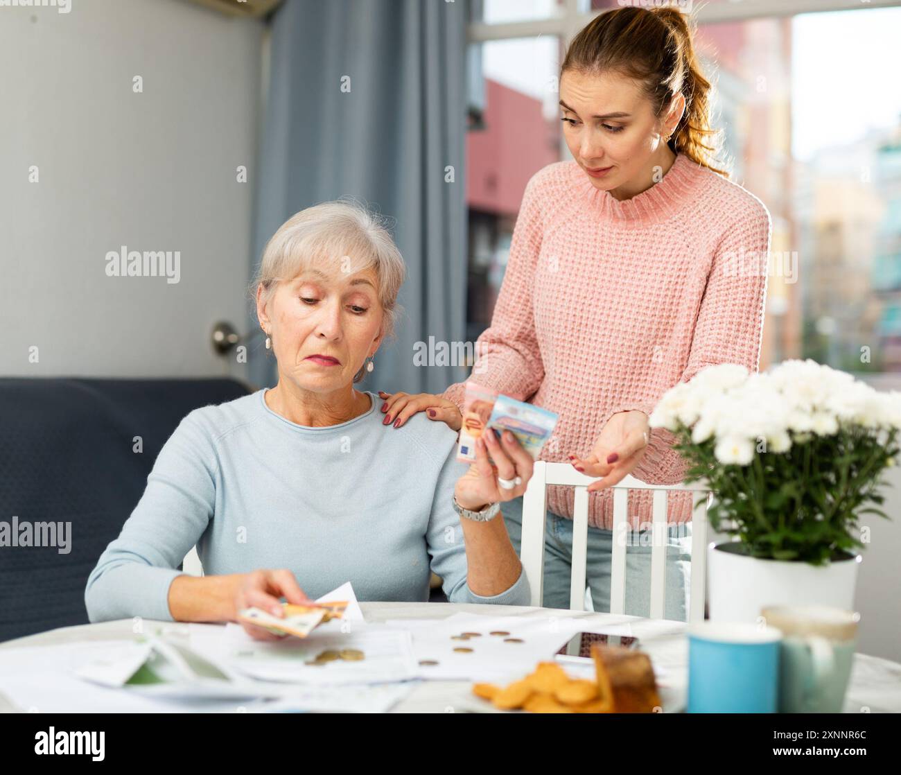 Girl asking for money from elderly mother calculating running costs of ...