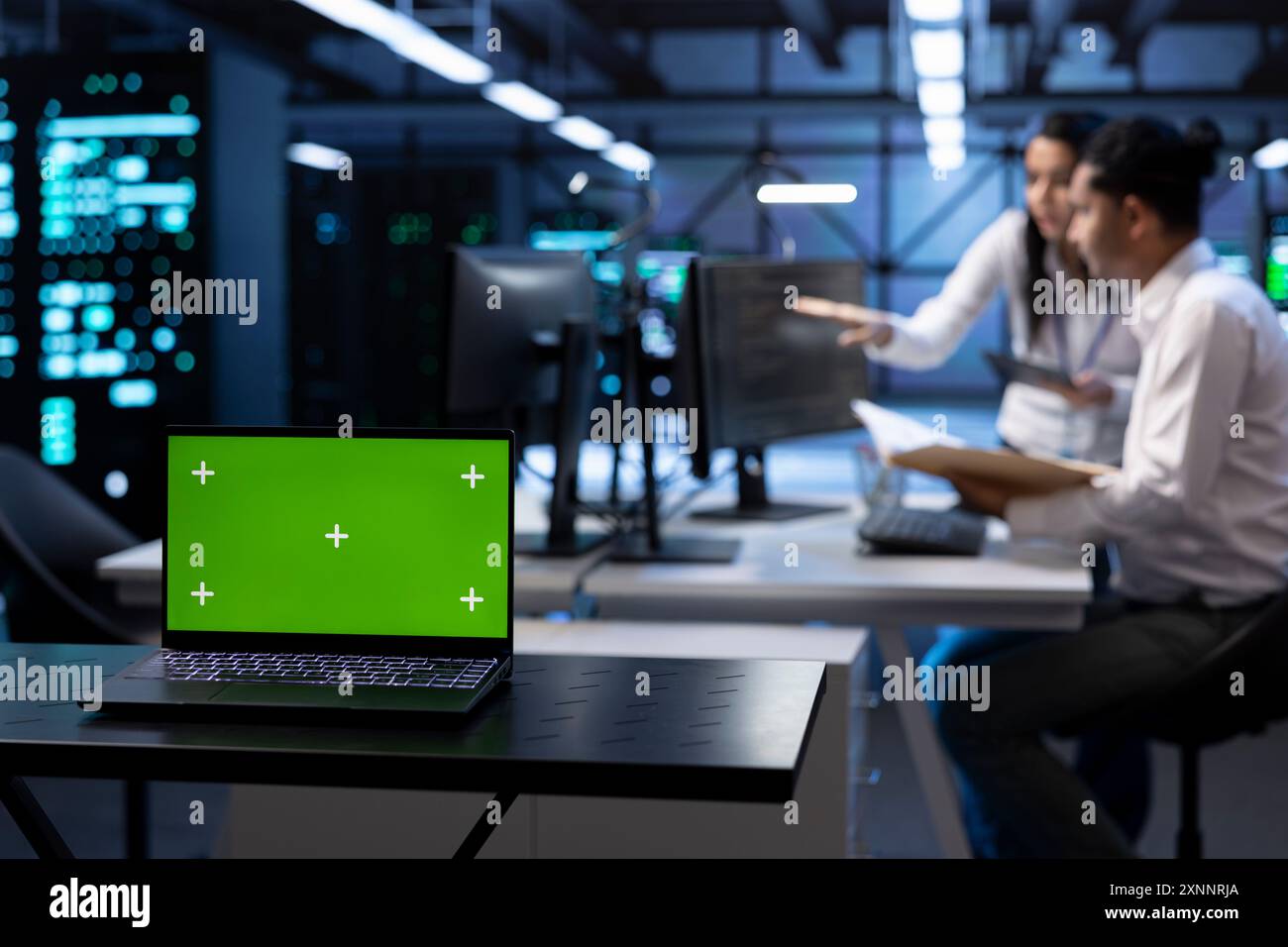 Close up of green screen laptop in data center with workers checking emergency procedures ...