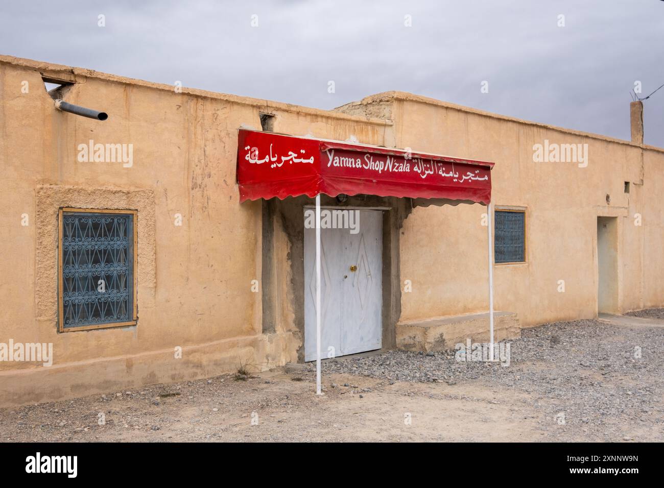 A small roadside bar with a red awning and a classic metal door typical ...