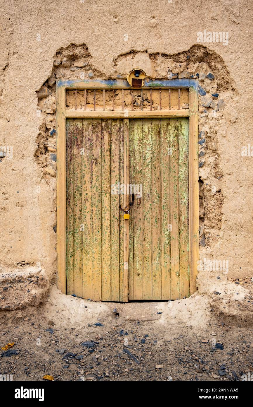 Old rusty metal door with stripped paint closed with a padlock in a ...
