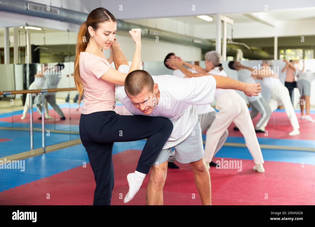 Girl with male opponent practicing elbow and knee strikes while locking ...