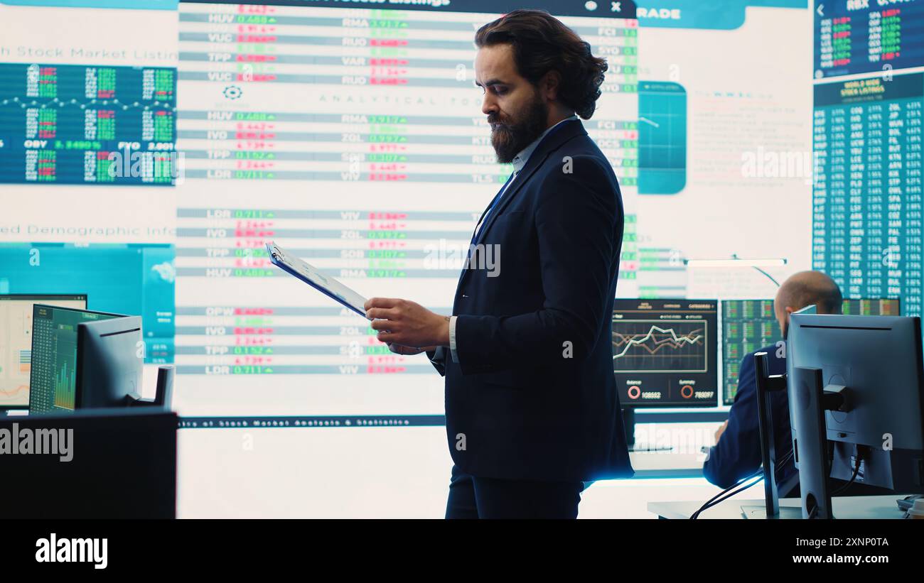 Chief executive officer reviews data shown on big display in the office ...