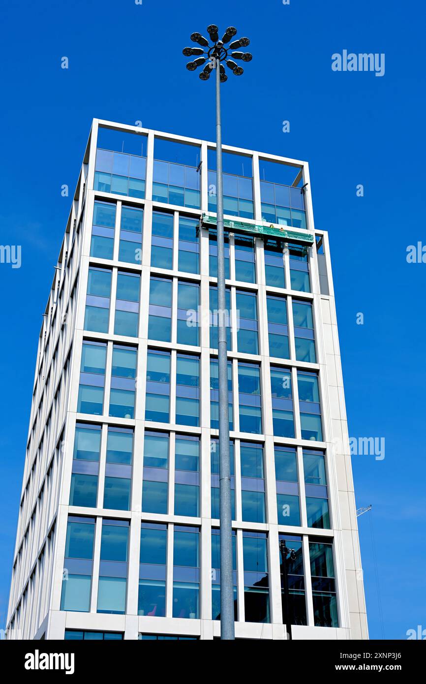Tower block window cleaning with massive street light and deep blue sky ...