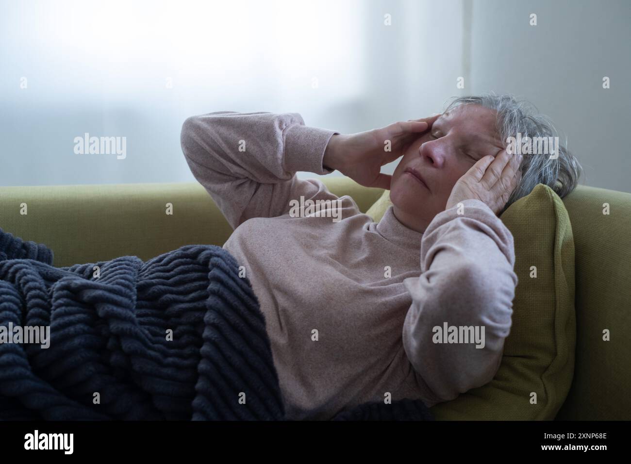 A sick old woman laying down in bed and having migraine Stock Photo - Alamy