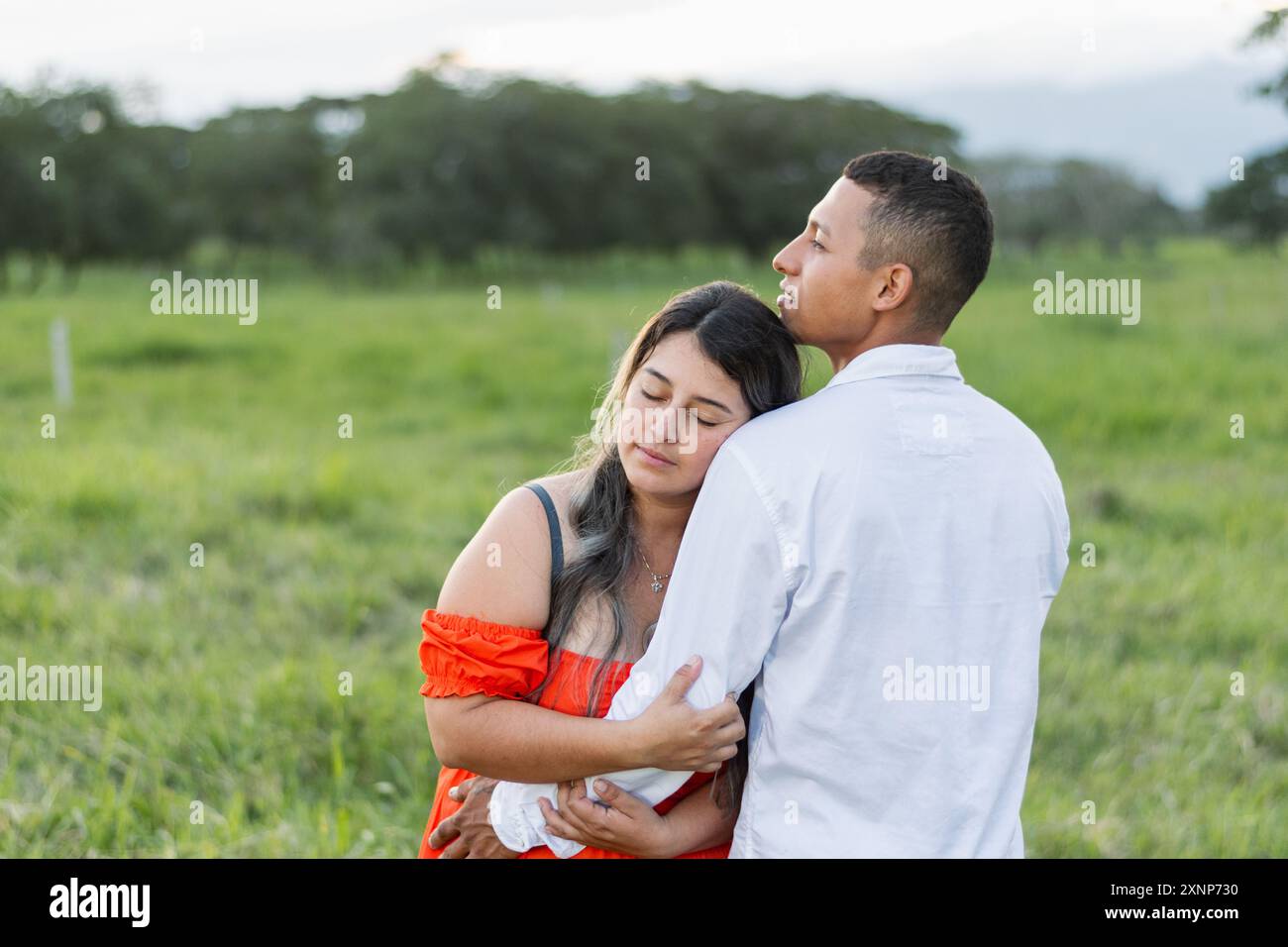 young latin couple, very loving caucasian woman hugging her boyfriend's ...