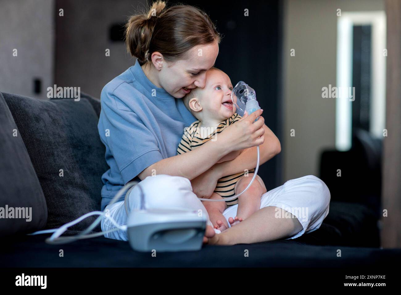 Woman putting on a mask up a nebulizer mask to her child's face Stock ...