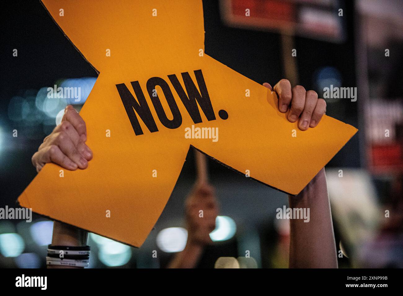 An Israeli holds a sign calling for a hostage release deal during a ...