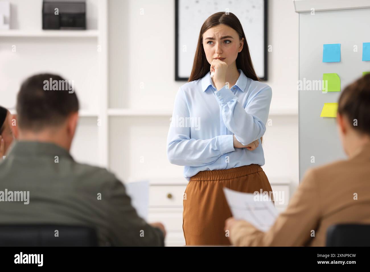 Woman feeling embarrassed during business meeting in office Stock Photo ...