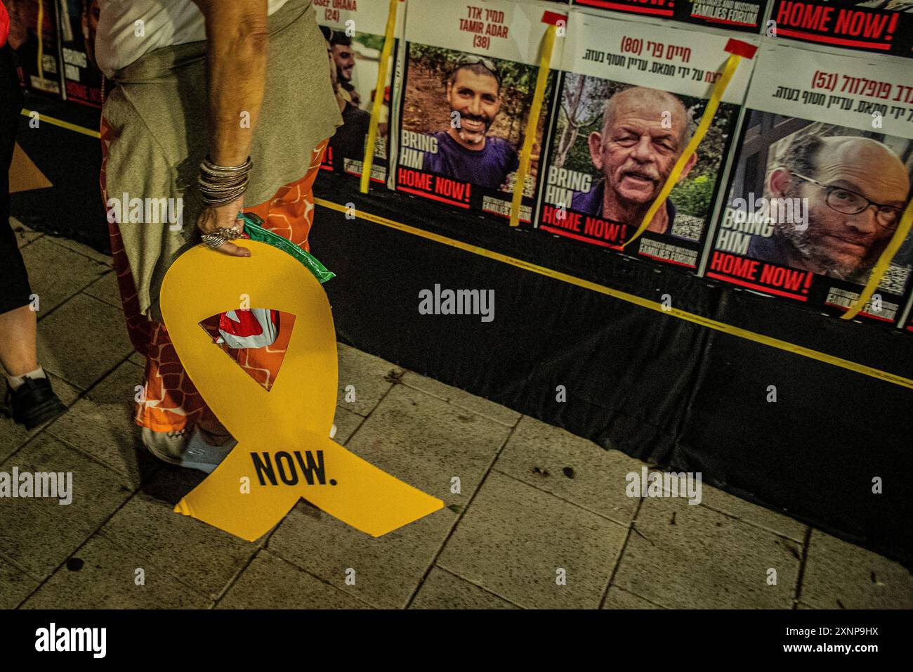 An Israeli woman drags a sign calling for a hostage release deal as she ...