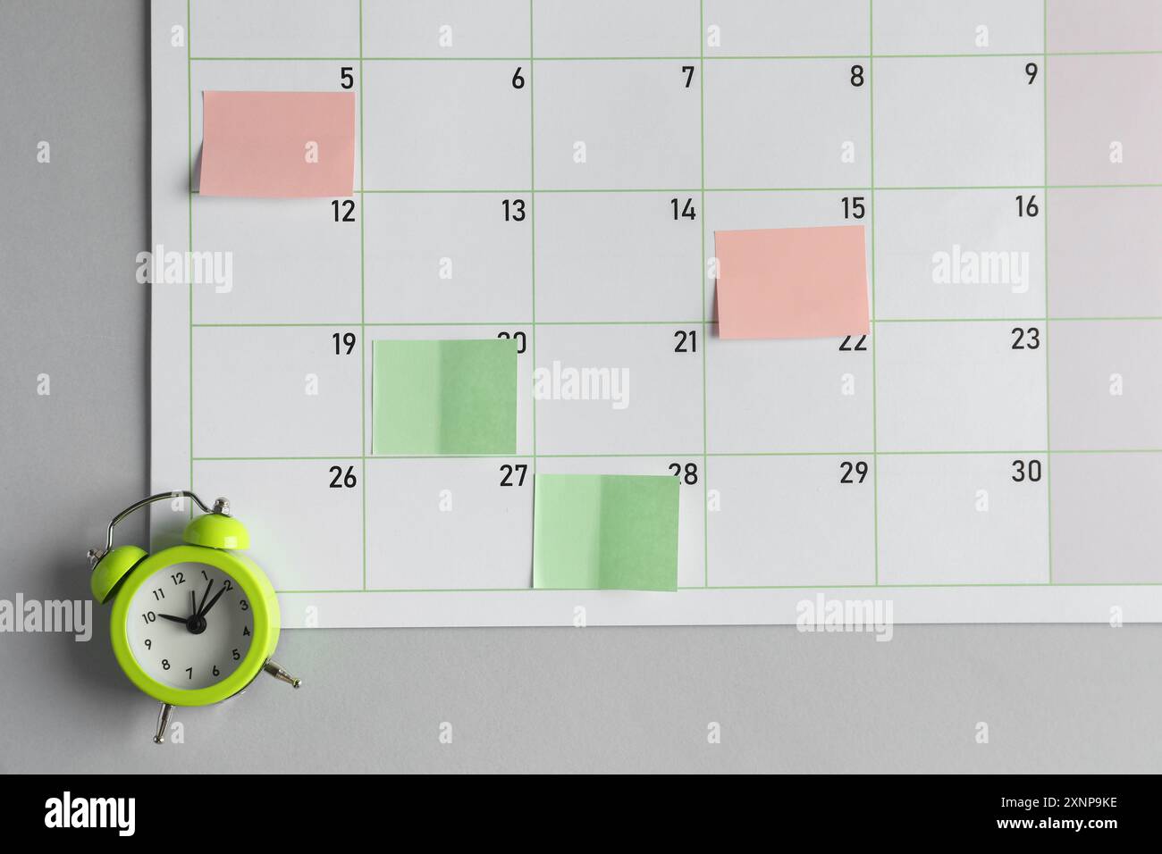 Timetable. Planner with sticky notes and alarm clock on grey table, top ...