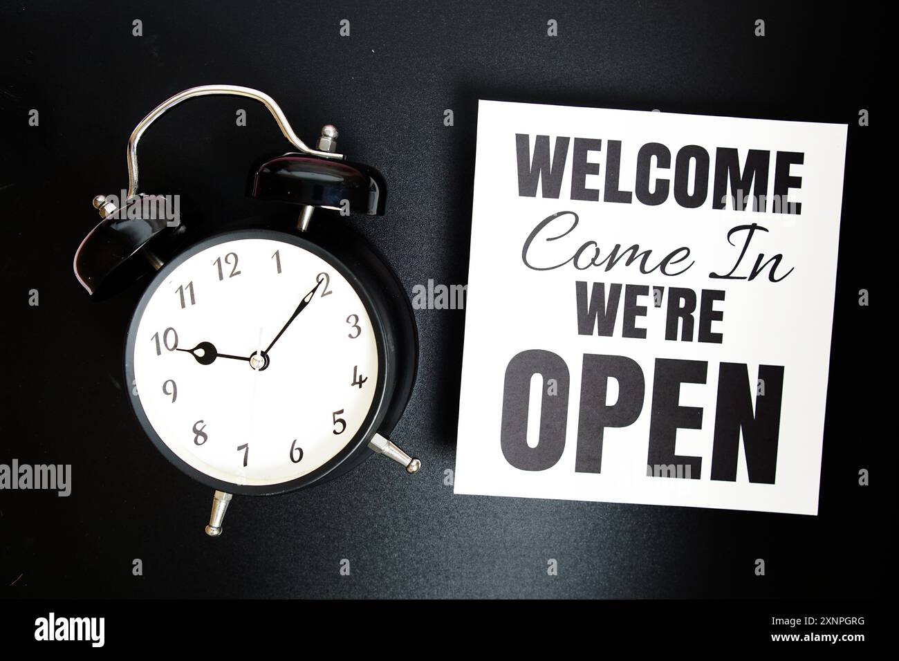 Welcome We're Open text with alarm clock on black background Stock ...