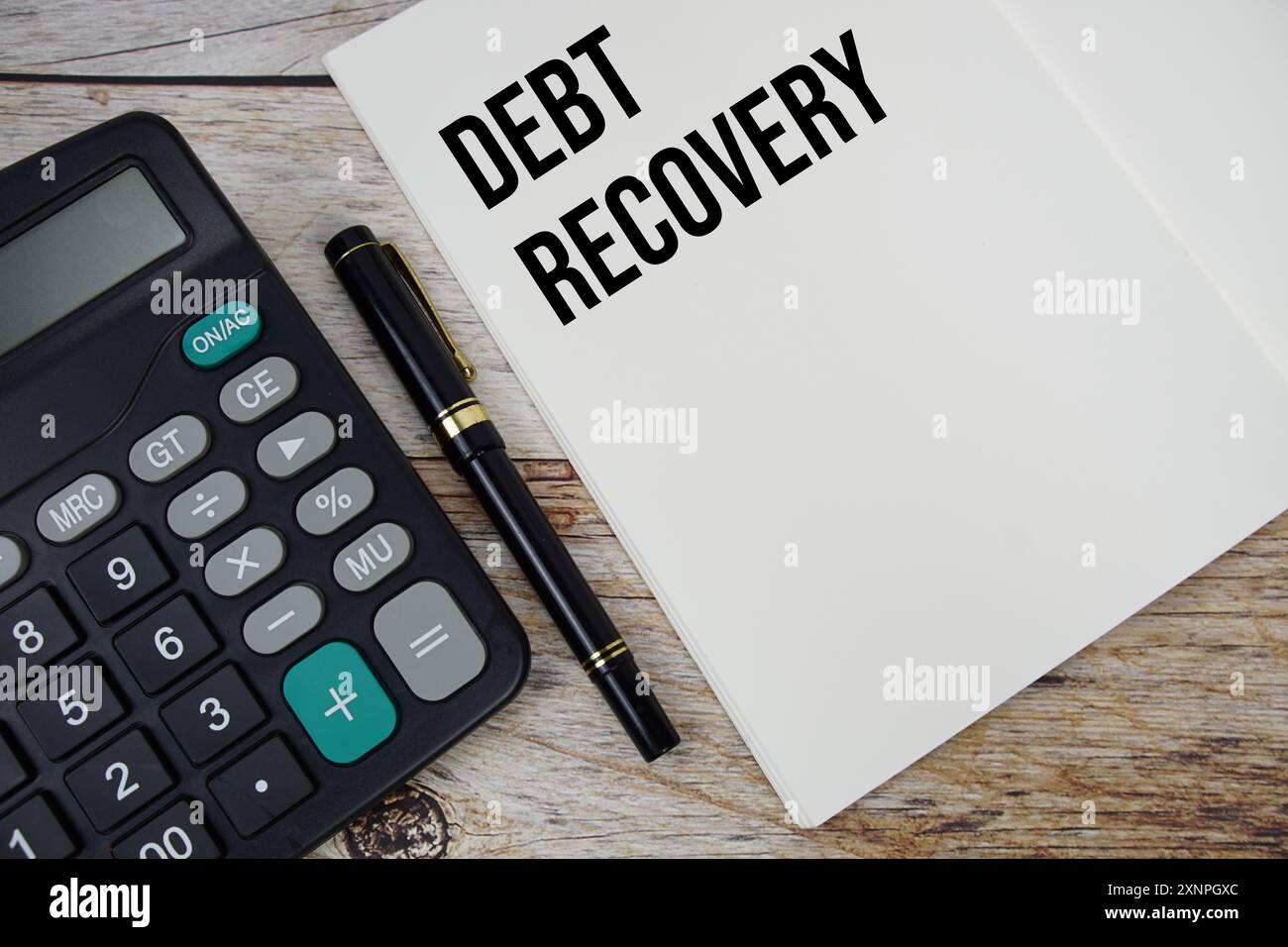 Debt recovery text on notebook page with alarm clock top view on wooden ...