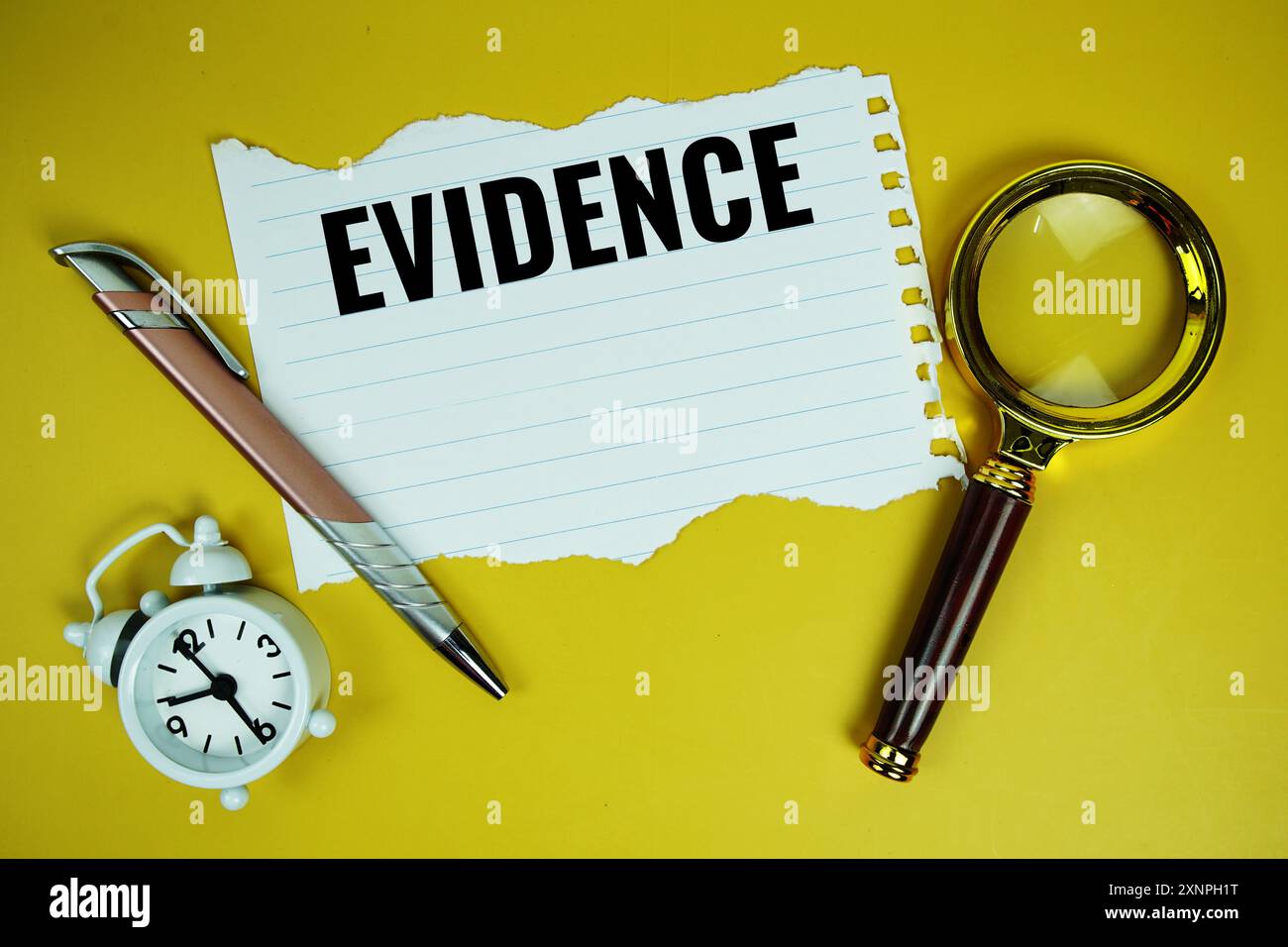 Evidence text on paper torn with alarm clock top view on yellow ...