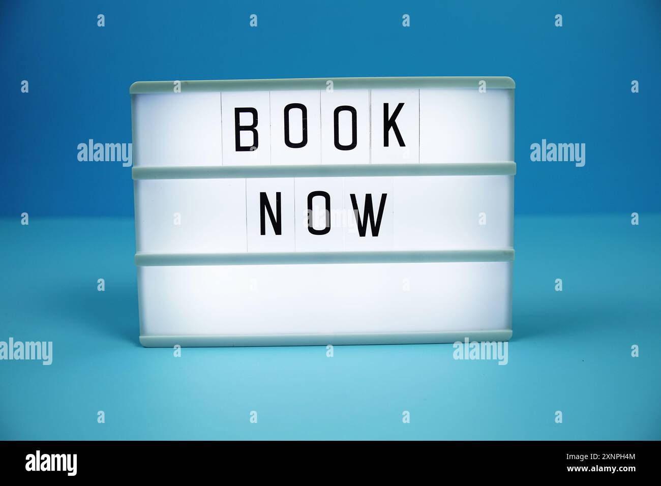 Book Now letterboard text on LED Lightbox on blue background Stock ...